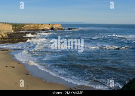 Santa Cruz coast line with cliffs and rocks. There're small waves on ...