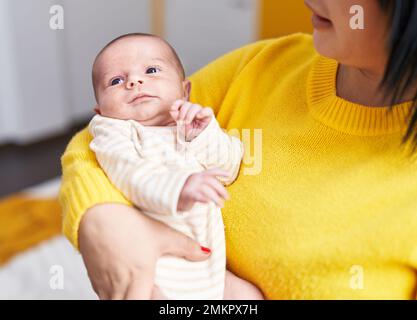 Adorable hispanic baby smiling confident lying on floor at kindergarten ...