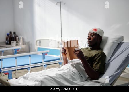 Soldier with bleeding head injury lying on hospital ward, view from ...