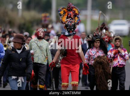 Revelers wearing colorful masks dance in the streets of Pillaro ...