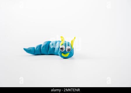 plasticine play dough wriggly worm in blue and yellow isolated on a ...
