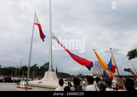A Philippine flag is partly torn while being raised during flag-raising ...