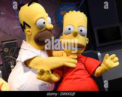 Costume characters Homer Simpson, left, and Bart Simpson participate in ...