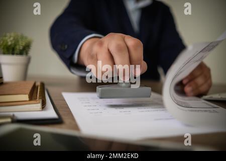 man stamping approval Text is approved by stamping the document on ...