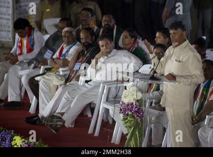 Telugu Desam Party (TDP) President N. Chandrababu Naidu, left, displays the victory symbol to ...