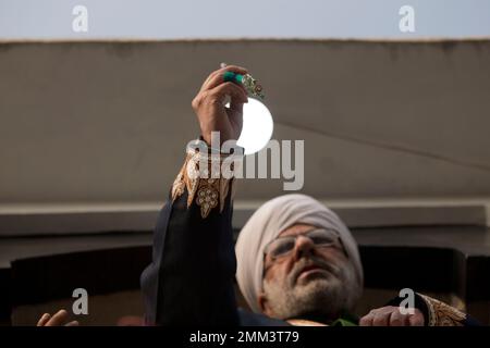 Kashmiri Muslims offer prayers as the head priest, unseen, displays a ...