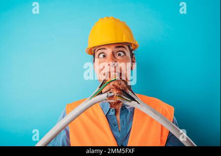 Shocked worker girl with helmet breaks an electric cable Stock Photo ...