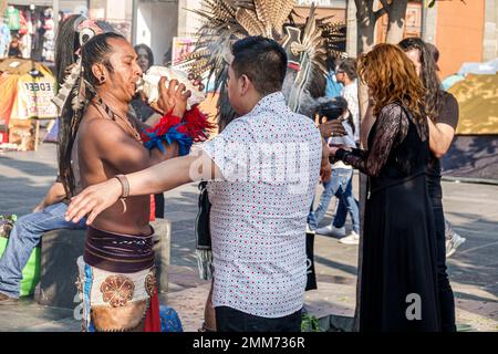 Mexican shaman performing a cleansing ceremony on a woman in the Zocalo ...