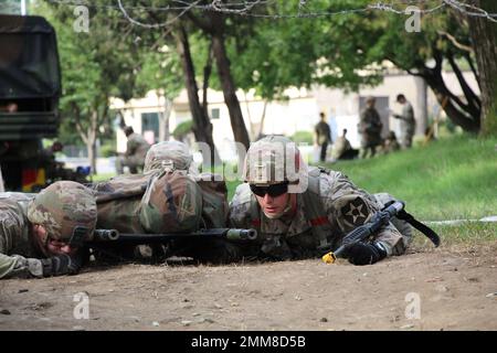 EFMB Candidate conducts the four-man litter carry under obstacles ...
