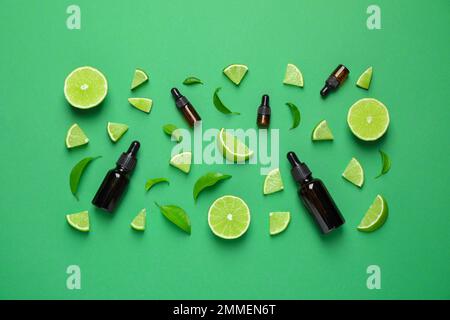 Composition with bottle of essential oil, lime and decor on color ...
