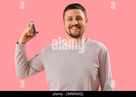 Sick man with inhaler on pink background Stock Photo - Alamy