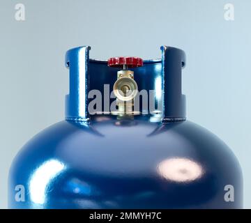 A generic metal gas cylinder with a bronze valve on an isolated white ...
