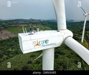 Two wind turbine technicians work on the nacelle of a turbine in the Sidrap Wind Farm area in ...