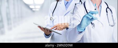 Cropped of medical team discussing over digital tablet at hospital ...