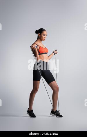 African american sportswoman jumping with rope on urban street Stock ...