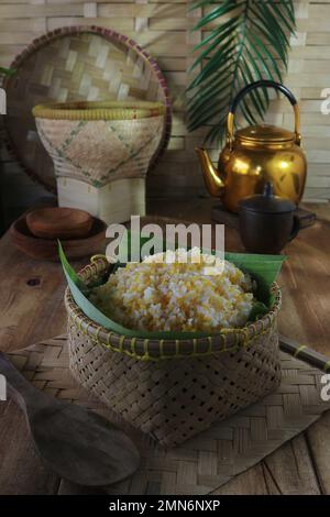 A dish with fish, rice and corn in a transparent dish plate on the ...