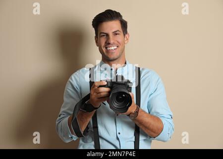Professional photographer working on beige background in studio Stock ...