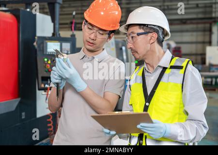 Two engineers wear protective overalls wearing helmets working in the ...