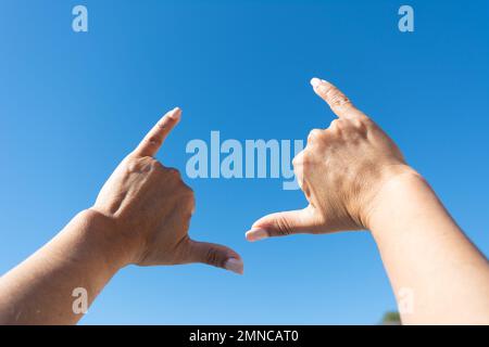 Woman's hands showing surfer sign against blue sky background Stock ...