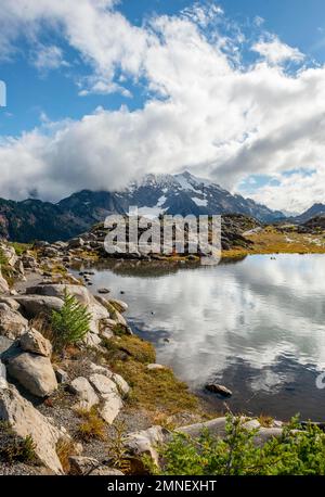 Lake at Huntoon Point, view of cloudy Mt. Shuksan with glacier and snow ...