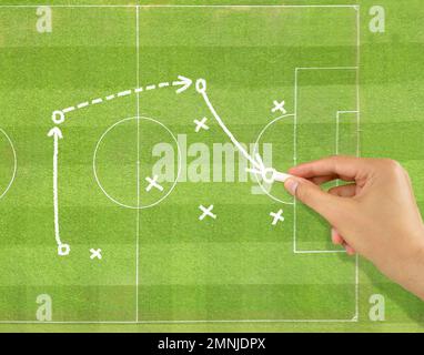 hand of a football coach drawing a tactics of soccer game with white ...