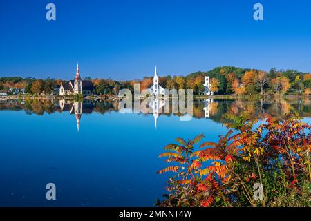 Reflections of churches with fall foliage color in Mahone Bay, Nova ...