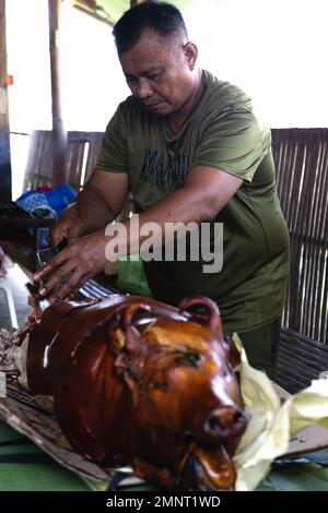 A Philippine Marine with 3rd Marine Brigade serves roasted pork to U.S ...