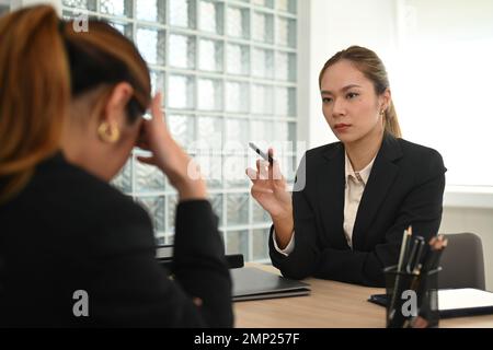 Furious female manager scolding young frustrated intern with bad work ...