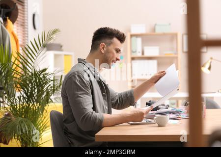 Journalist with papers at workplace in office Stock Photo - Alamy