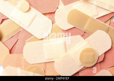 Different medical sticking plasters as background, closeup. First aid ...