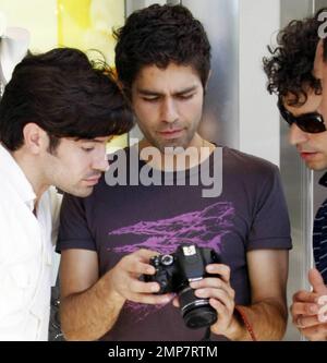 "Entourage" actor Adrian Grenier walks with a man in a fire suit and ...