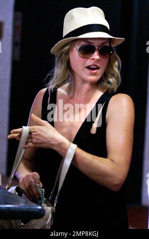 Wearing a black mini dress with a tan hat and sunglasses on a hot ...
