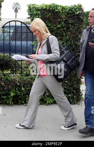 Comedienne and actress Amy Poehler goes over a script as she strolls on ...