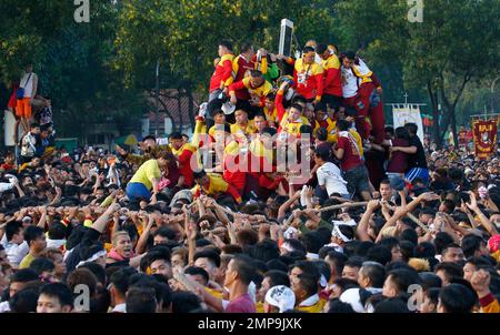 Filipino Roman Catholic devotees jostle to kiss and rub with towels the ...