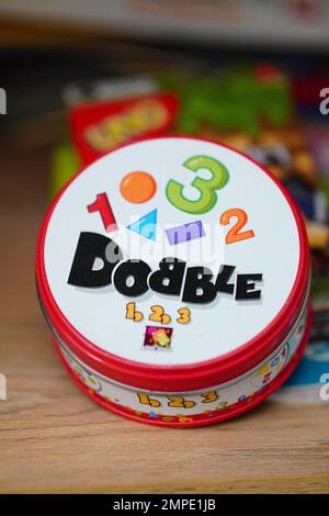A dobble brand card game with numbers and shapes in a metal box Stock ...