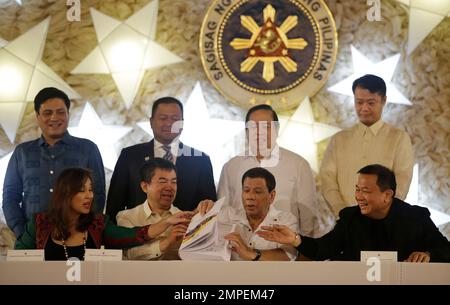 Philippine President Rodrigo Duterte is assisted as he removes his face ...