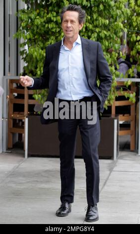 Producer Brian Grazer wears a black suit and white shirt while out and ...