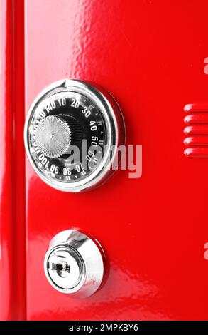 Red steel safe with mechanical combination lock on black background ...