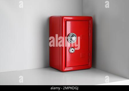 Red steel safe with mechanical combination lock on shelf. Space for ...