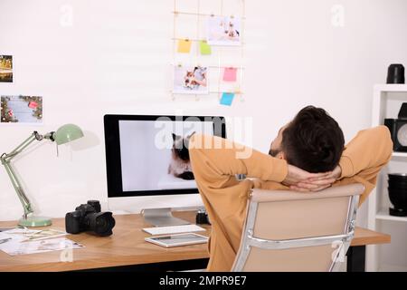 Professional photographer resting at workplace in office Stock Photo ...