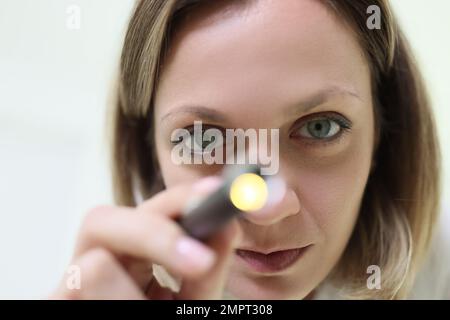 Doctor anesthesiologist resuscitator shining medical flashlight into ...