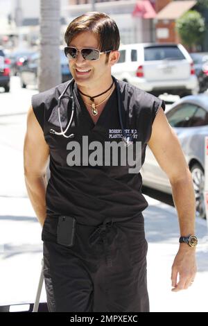 With a stethoscope around his neck plastic surgeon Robert Rey aka Dr. 90210 smiles for the cameras as he heads to his office pulling along a crate of supplies and paperwork. Los