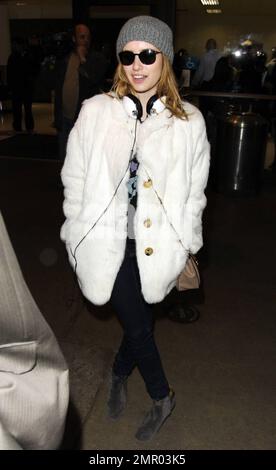 Actress Emma Roberts looks warm in a white fuzzy coat and grey hat as ...