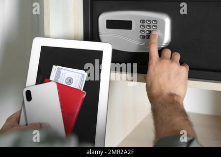 Man opening steel safe with electronic combination lock, closeup ...