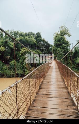 A vertical shot of a wooden bridge leading to a beach during sunrise ...