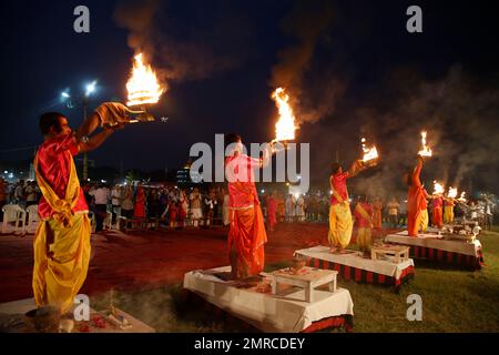 A Hindu priests rotate traditional oil lamps in circular movements as ...