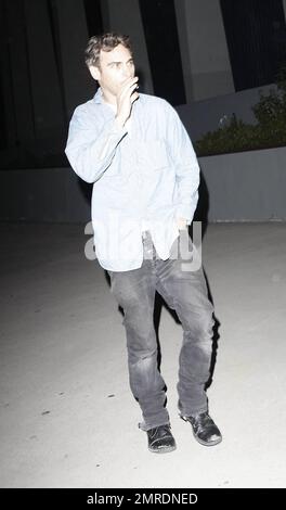 Actor turned rapper, Joaquin Phoenix, smokes a cigarette as he arrives ...