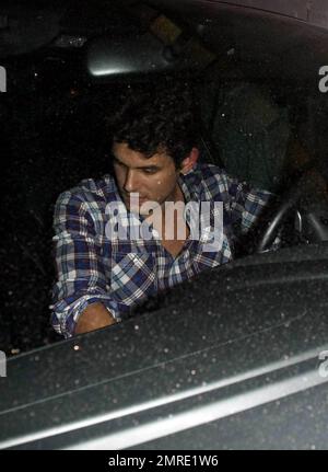 Musician John Mayer signs a guitar for a fan as he leaves the Hotel ...