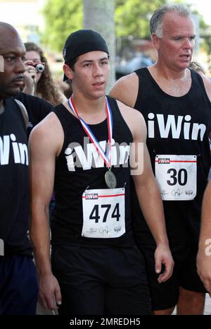 Nick Jonas (C) of the Jonas Brothers finishes the Joe Jonas iWin 5K Fun ...