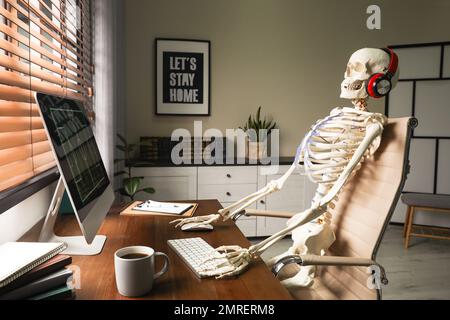 Human skeleton with headphones using computer at workplace Stock Photo ...